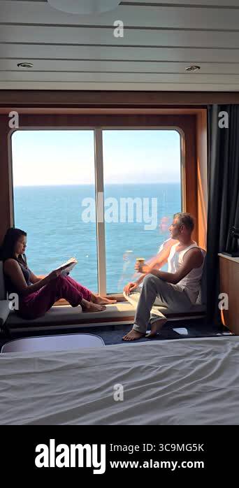 Two individuals relax in a cozy cabin aboard a ship, enjoying the ...