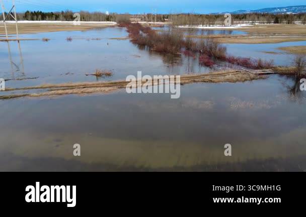A stream overflows its banks due to a spring flood and flows just under ...