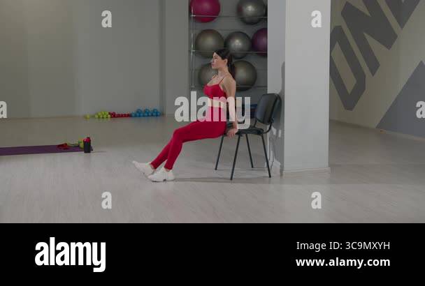person demonstrates reverse chair pushups targeting the triceps in a ...