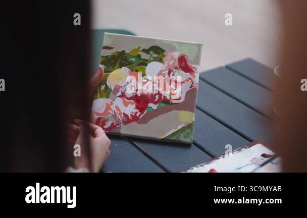 Talented artist who delicately applies paint to canvas creating floral ...