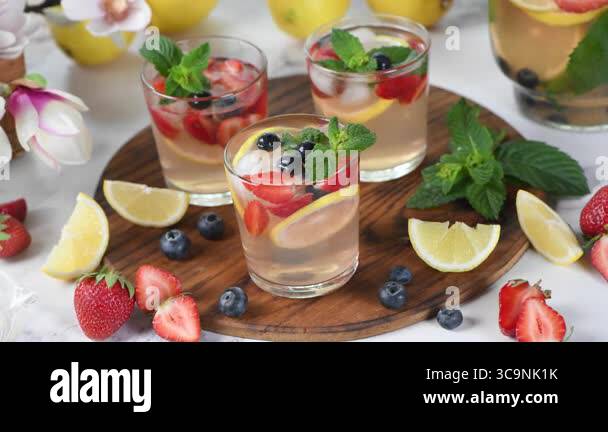 Summer lemonade with strawberries, blueberries and mint. Horizontal ...