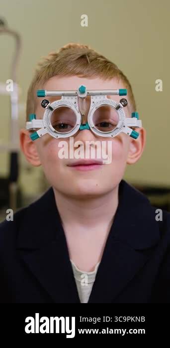 Happy child wearing a trial frame during an eye examination at an ...