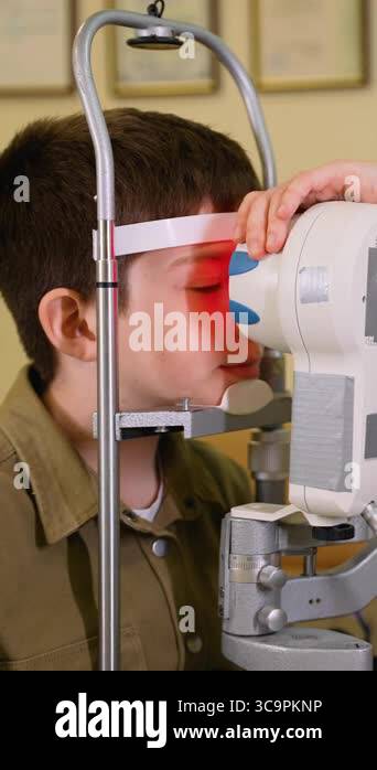 Professional optometrist performing precise eyesight screening of young ...