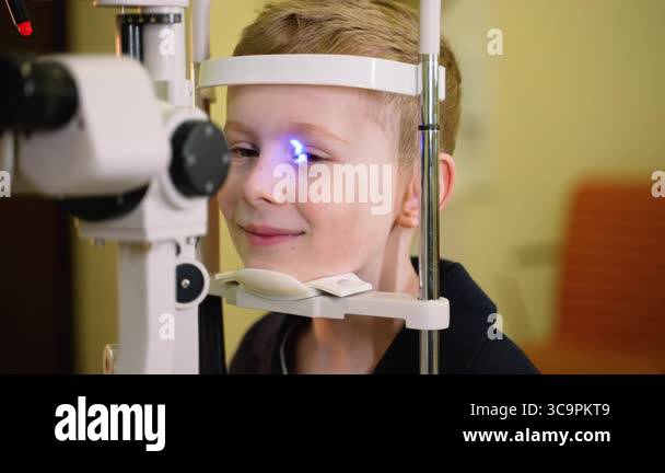 Pediatric ophthalmologist examining a childs eye with a modern slit ...