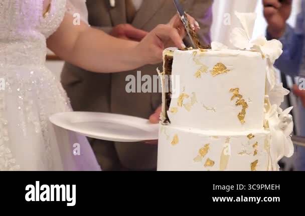 Beautiful wedding cake being cut by the bride and groom. Wedding ...