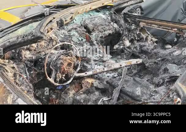 Interior of a burned car, showing extensive fire damage to the steering ...