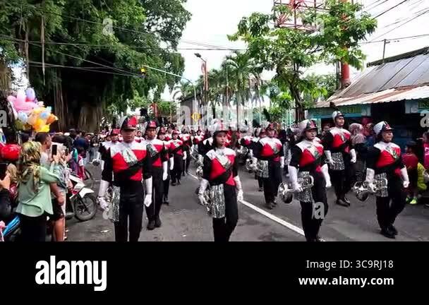 A drum band group is playing musical instruments while walking on the ...