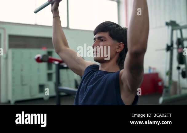 Male fitness enthusiast strengthens back muscles with lat pulldown ...