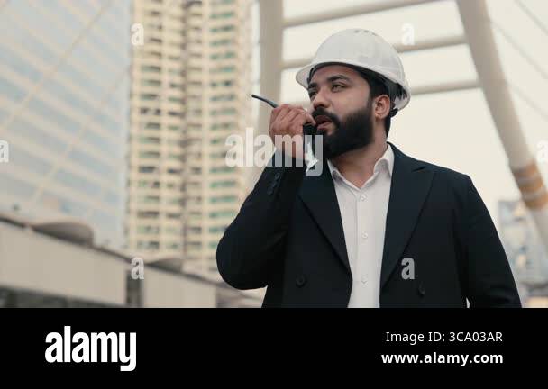 Portrait of concentrated Indian supervisor in office jacket talking on ...