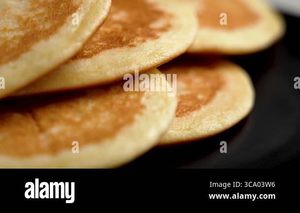 Fresh homemade pancakes with baked golden texture on black ceramic ...