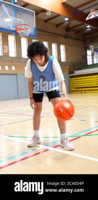 Female basketball player practicing ball dribbling skills, confidently ...