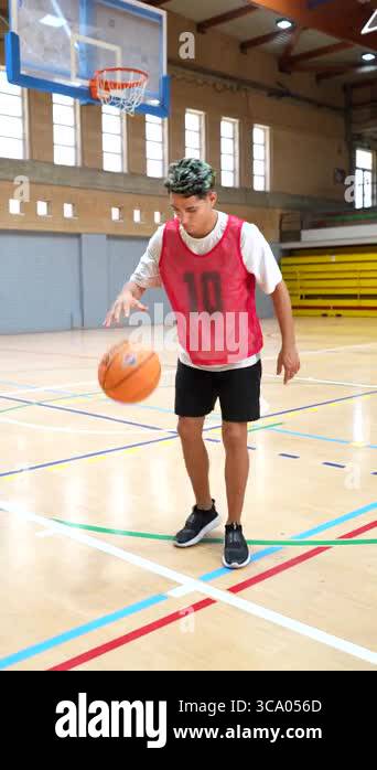 Young basketball player practicing his dribbling skills and posing for ...