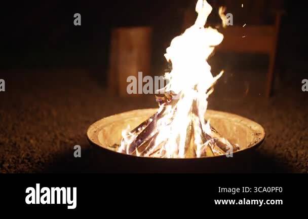 Flames in modern outdoor fire pit set in private backyard. The ...