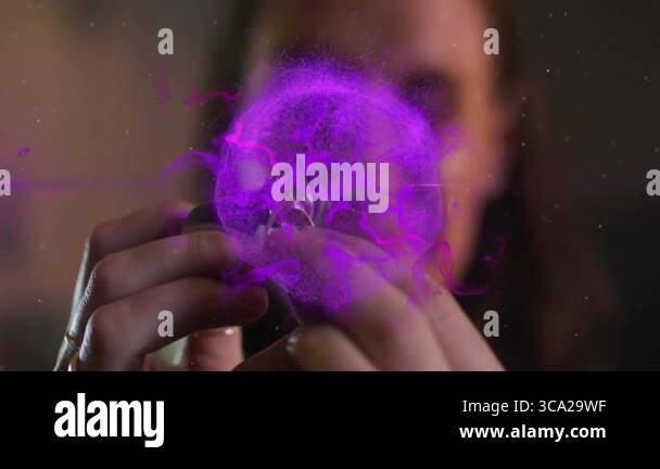 Woman bringing handheld device between fingertips and generating purple ...