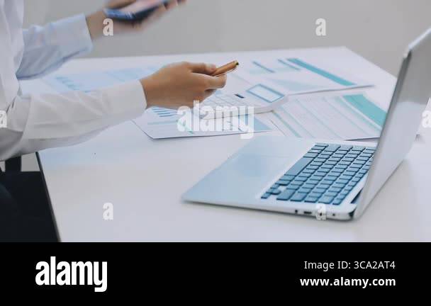 businessman working on laptop computer and financial report in office ...