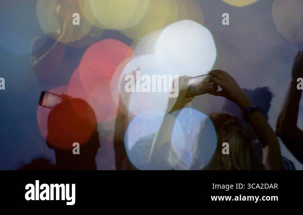 woman holding phone recording gig, overlaying animated soundwave ...