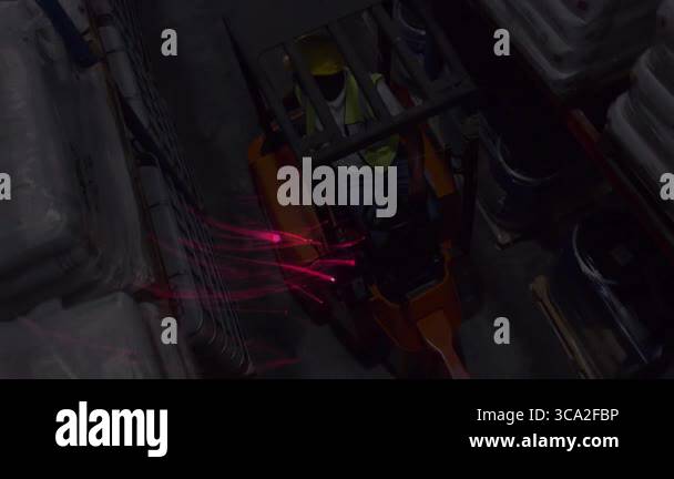 Forklift operator loading pallets in warehouse, with red light streaks highlighting logistics ...