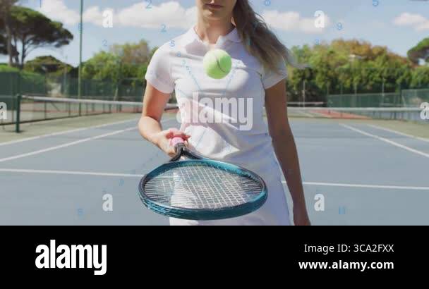Woman balancing neon tennis ball on racket on tennis court, with ...