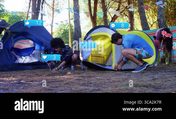 Outdoor education team pitching pop-up tents in forest clearing ...