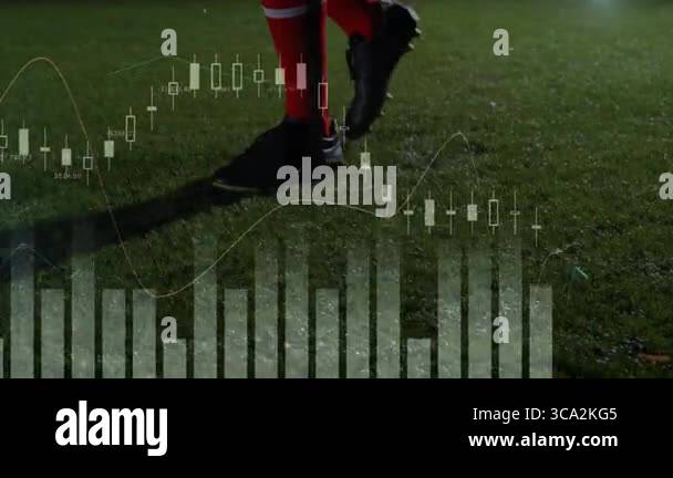 Soccer player tapping ball on floodlit pitch executing dribble as ...
