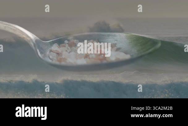 Salt grains falling into silver spoon on blue cloth, striking,bouncing ...