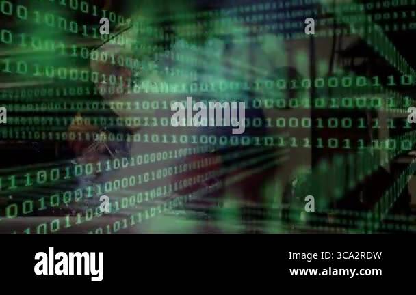 Programmer wearing glasses coding at desk under binary code overlay ...