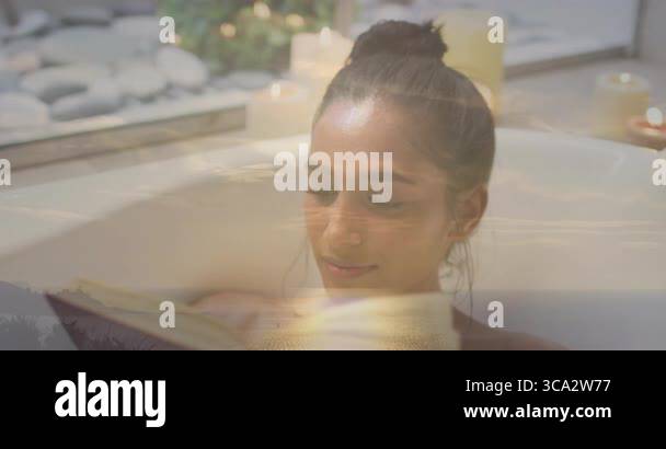 woman reading book in bathtub spa scene, showing animated candle flames ...
