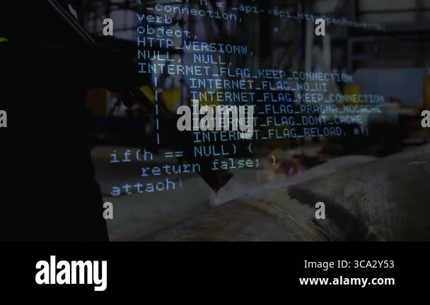 Senior technician operating workbench in factory, with code overlay ...