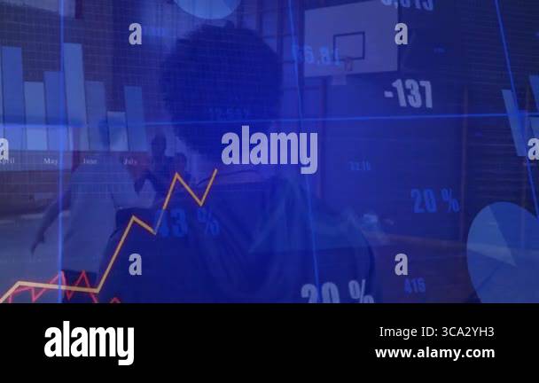 Male player preparing to shoot basketball in gym, overlaying finance ...