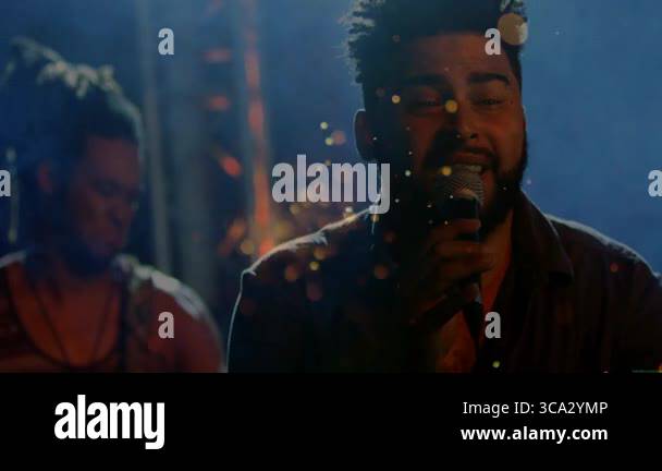 Singer holding mic and guitarist playing guitar under concert lights ...