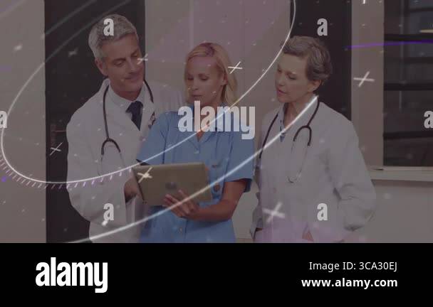 Medical team reviewing tablet in clinical corridor, displaying animated ...