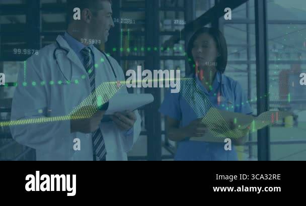 Medical professionals reviewing charts in hospital corridor, showing ...