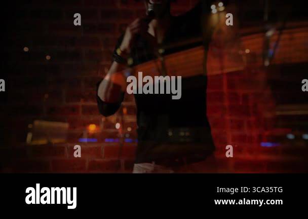 Male singer leaning forward on stage, projecting animated music ...