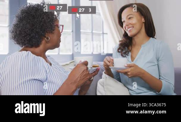 Two women sharing tea and cookies in bright living room, with floating ...