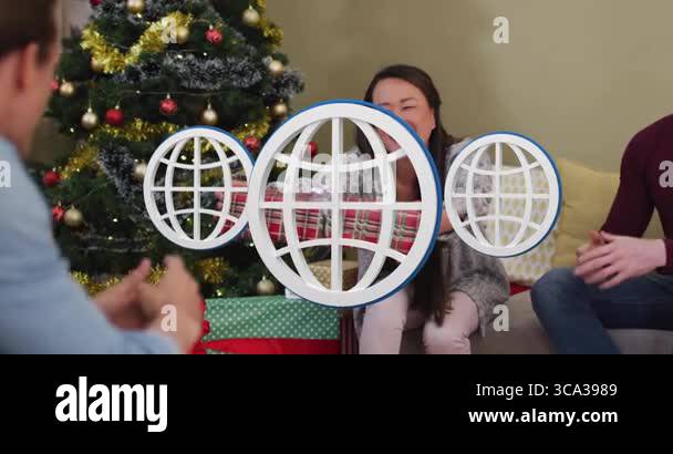 Friends exchanging gifts by Christmas tree, with floating marketing ...