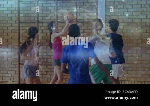 Teenage teammates practicing shooting basketball hoops in gym, showing ...