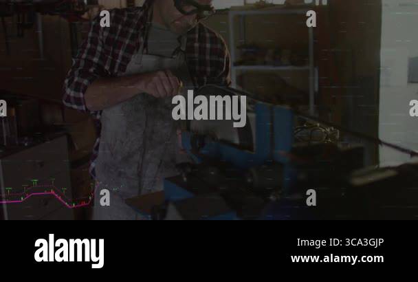 male craftsman sharpening metal on bench grinder in workshop, showing ...