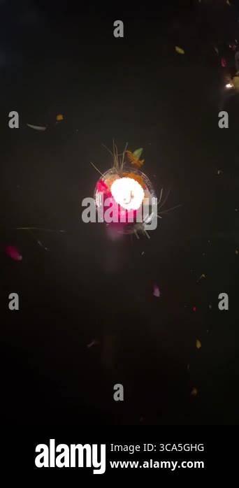 Ganga aarti, Fire flame along with rose and marigold flower floating in ...