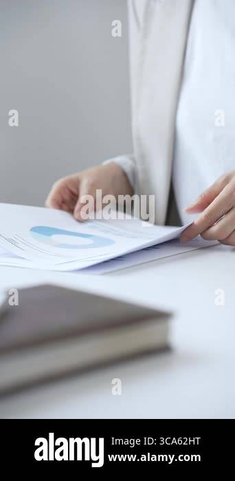 Businesswoman reviewing financial documents and charts, performing data ...