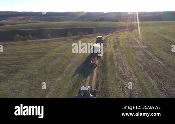 Flying over agricultural machinery driving on country road after ...