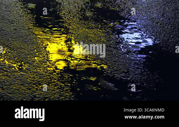 Vibrant abstract reflection of yellow and blue light on rainsoaked ...