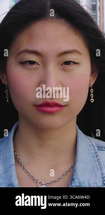 Vertical HD video portrait of young asian girl smile at camera standing ...