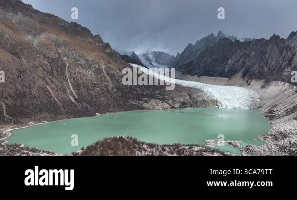 Aerial view of beautiful glacier and lake in high altitude mountains ...