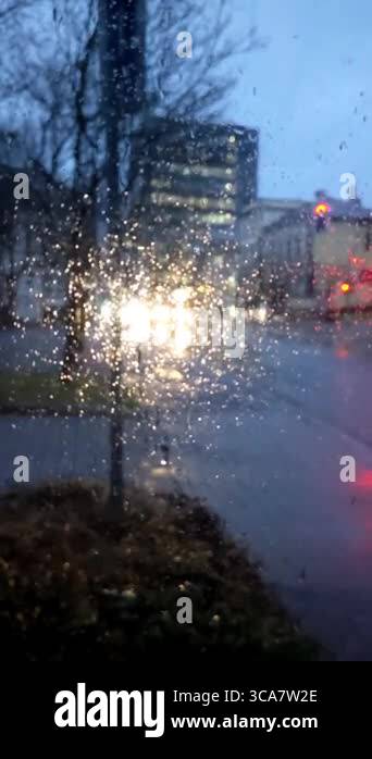 blurred background of the city. rain drops on the window, traffic at ...