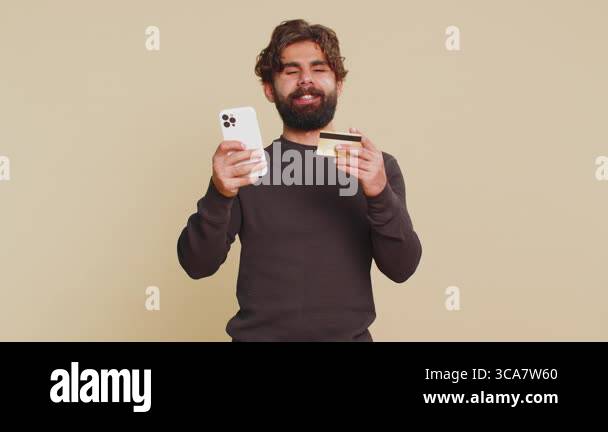 Happy Lebanese man customer using credit bank card and smartphone while ...