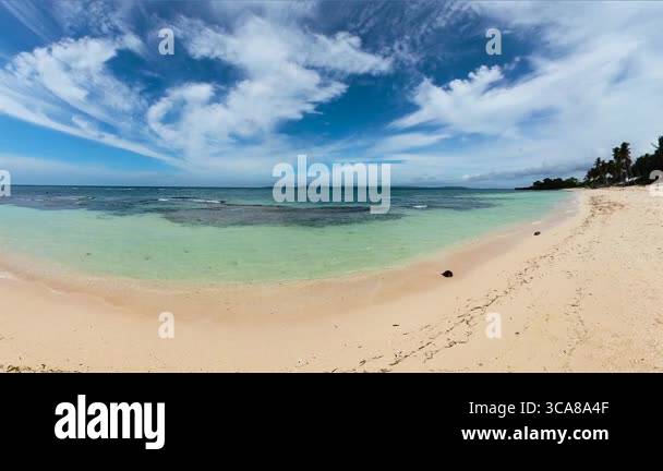 Ocean waves on sandy beach. Blue sky and clouds. Carabao Island in ...