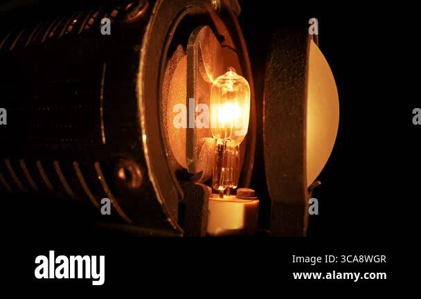 A glowing halogen light bulb housed inside a professional spotlight or ...