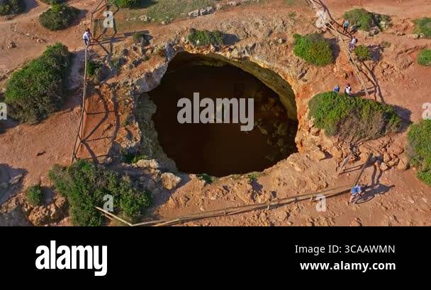 Aerial view of Benagil Cave, viewed through the circular cliff-top hole ...