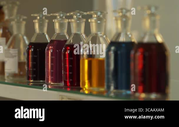 Glass bottles with colorful chemicals sit on a shelf in the laboratory ...