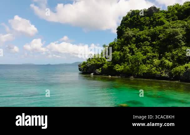 Island with turquoise sea water and corals. Blue sky and clouds. El ...